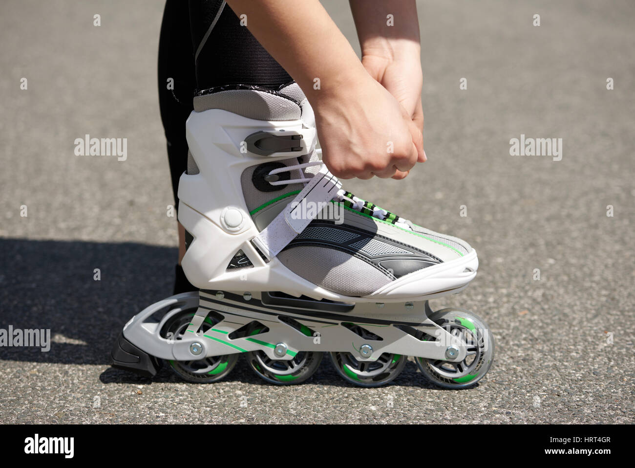 Woman is going roller skating. Putting on inline skates. Close up ...