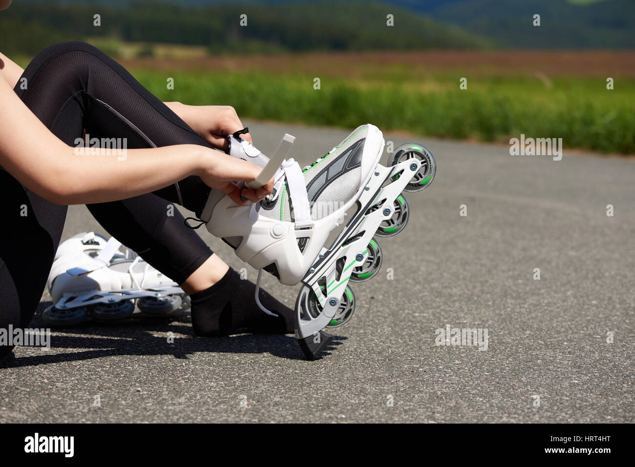 Woman is going roller skating. Putting on inline skates. Close up ...