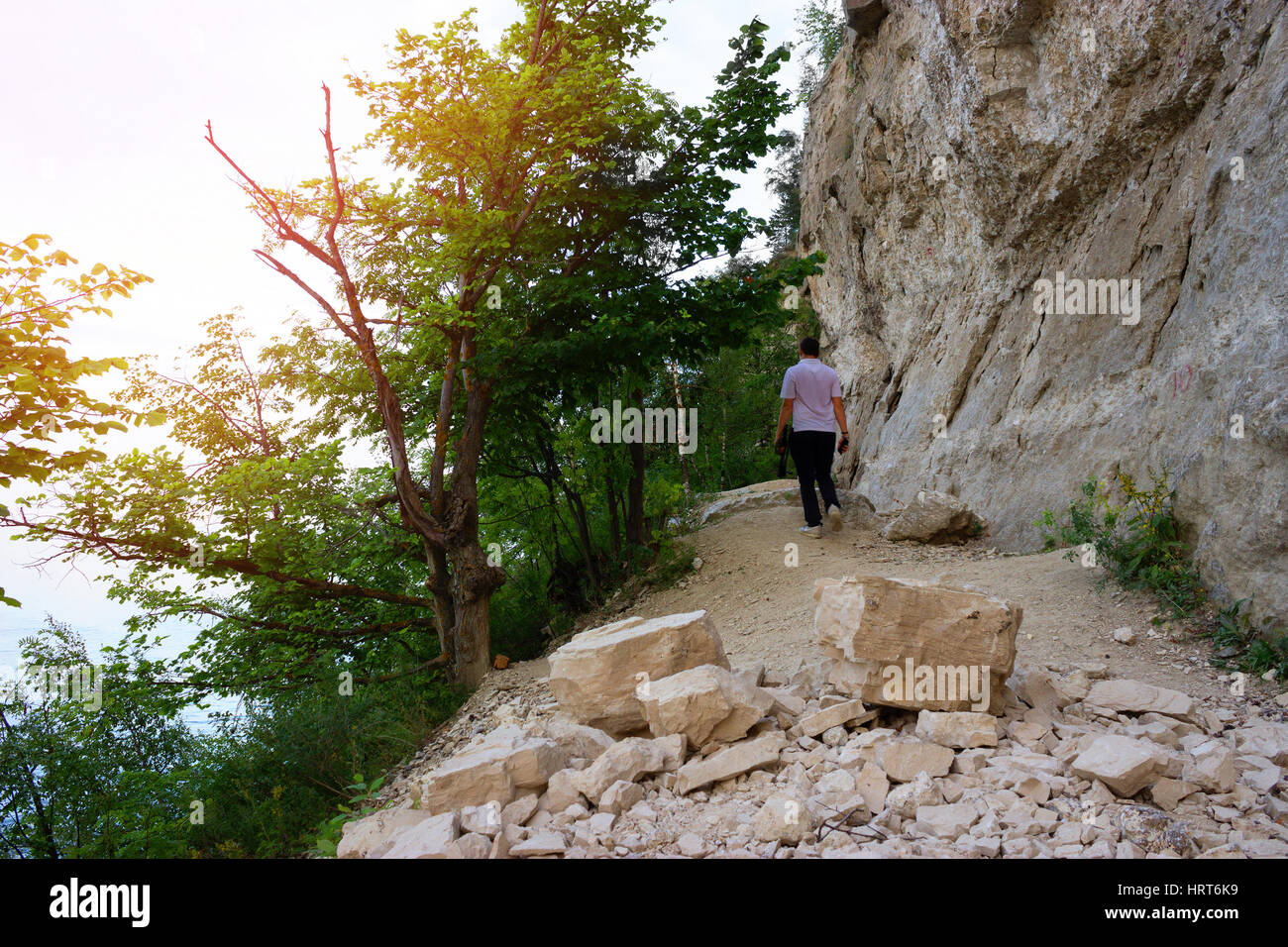Men and dog on rocky road. trees Stock Photo - Alamy