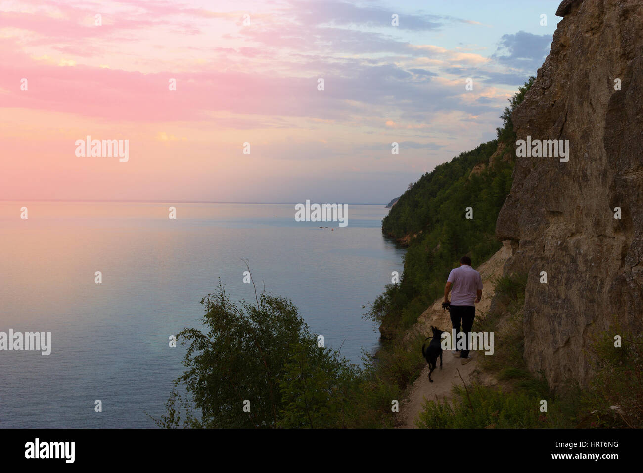 Men and dog on rocky road. trees Stock Photo - Alamy