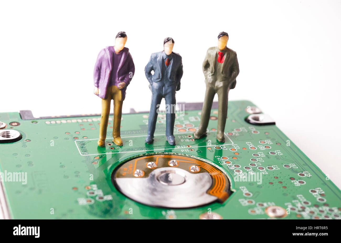Miniature figurines of three men standing on computer hard drive Stock ...