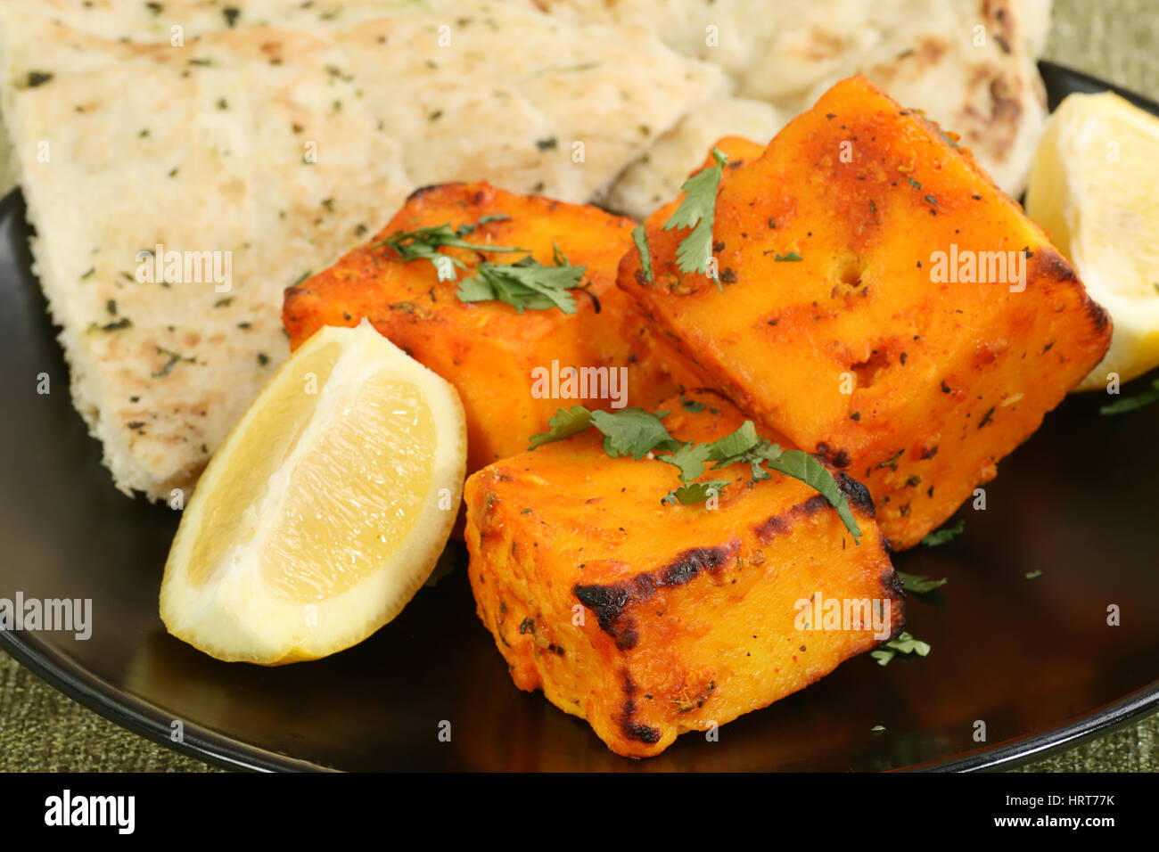 four pieces of marinated paneer cheese with coriander and lemon Stock ...