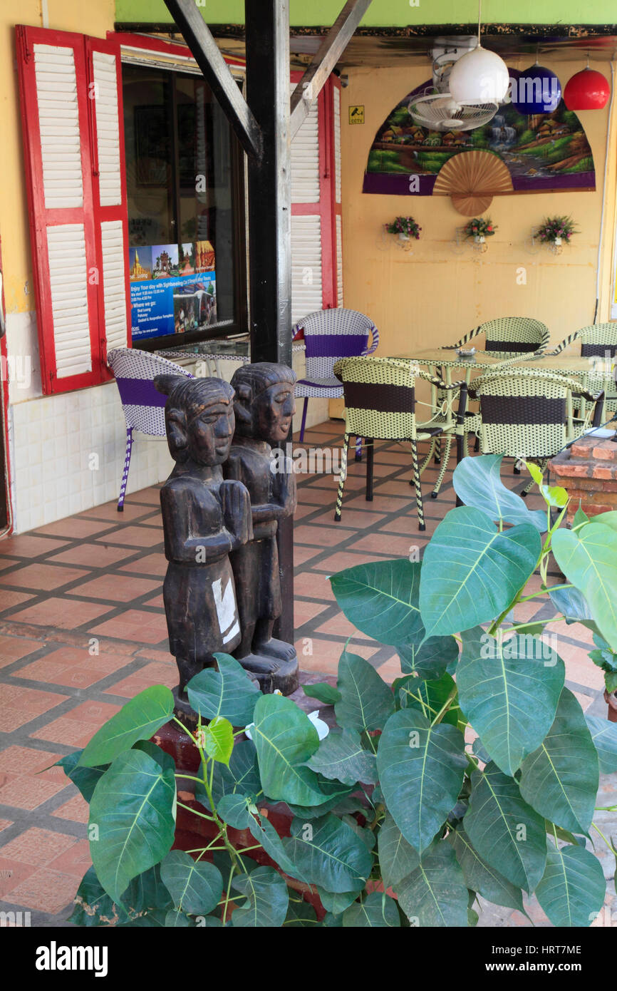 Laos, Vientiane, cafe terrace, statues, plants, street scene Stock ...