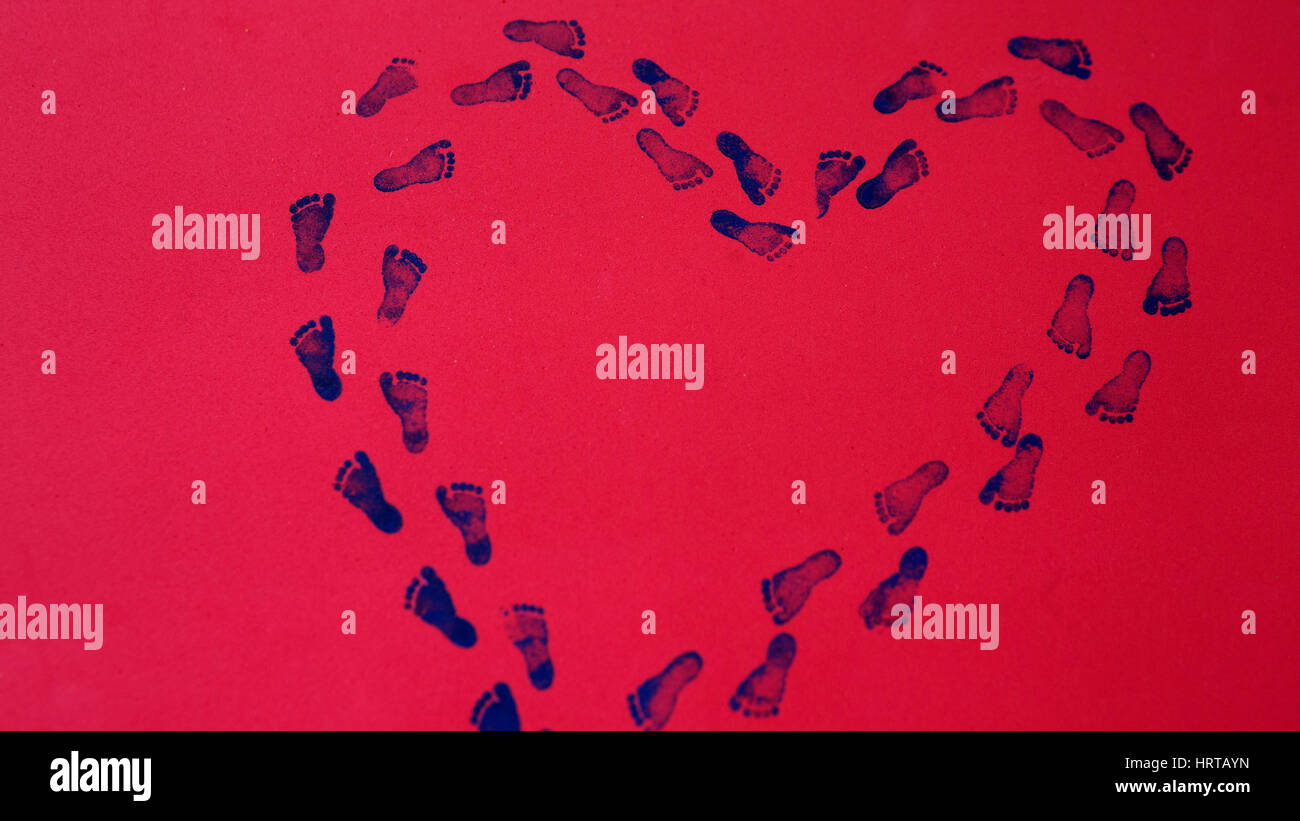 drawing of footsteps in shape of heart on red paper Stock Photo - Alamy