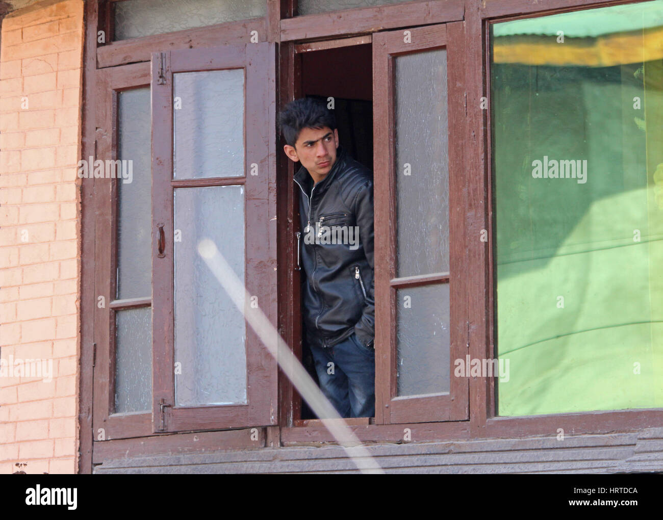 Srinagar, Kashmir. 03rd Mar, 2017. A boy watching the clashes through a ...