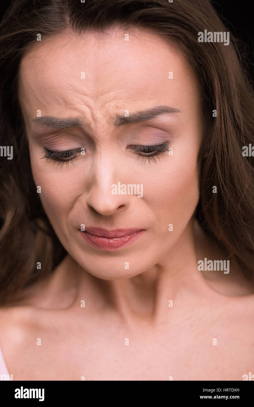 Close-up portrait of beautiful young woman crying and looking down ...