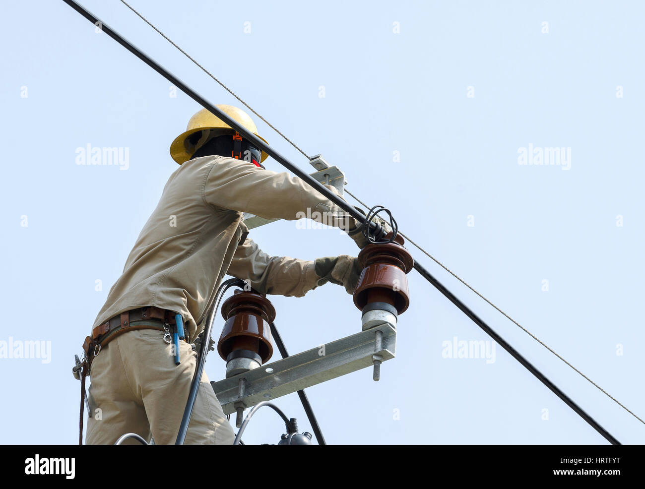 One electrician is installing of new support and wires of a power line ...