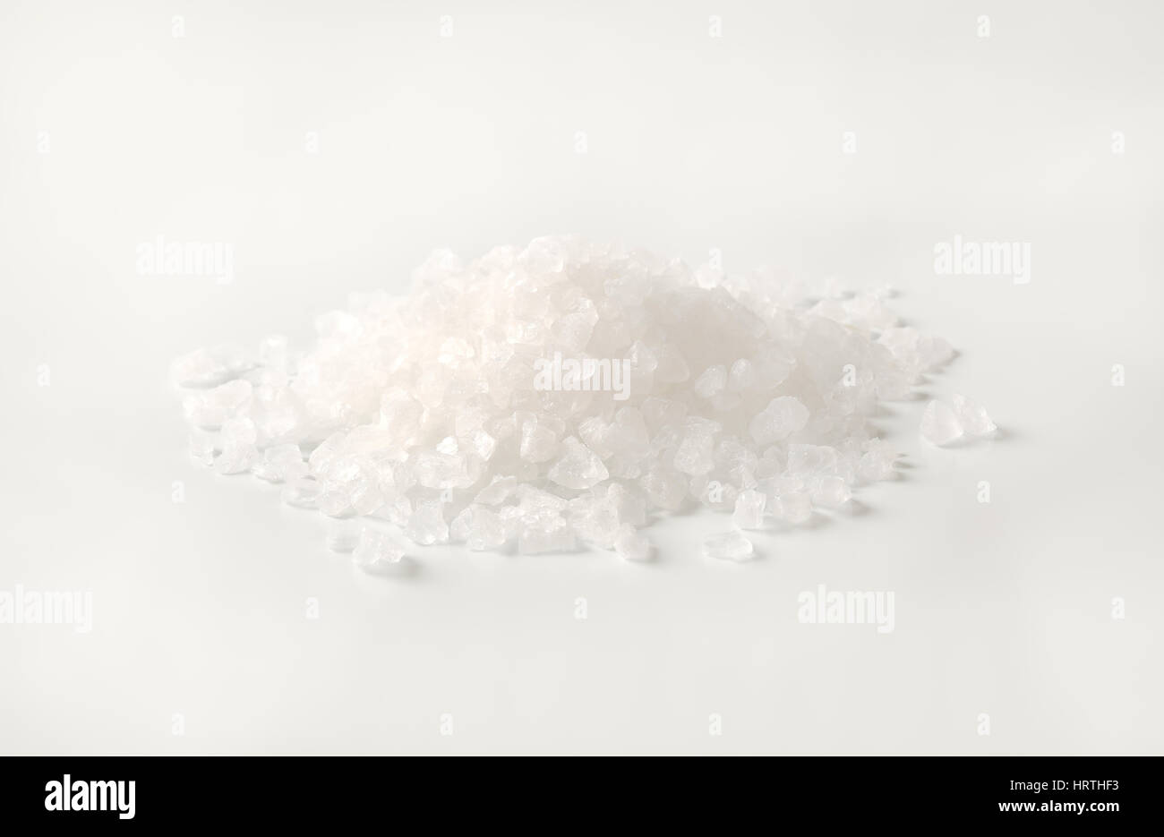 pile of coarse grained salt on white background Stock Photo - Alamy