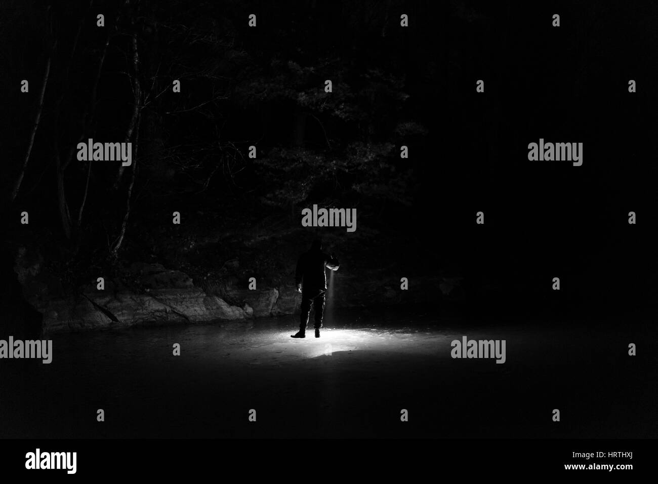 Human with flashlight standing on a ice lake at night. Sweden ...