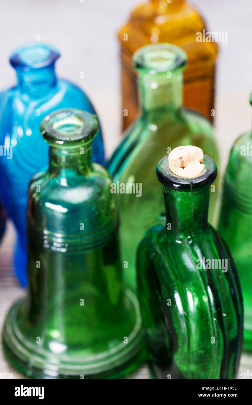 Selection of coloured glass bottles on a rustic background Stock Photo ...