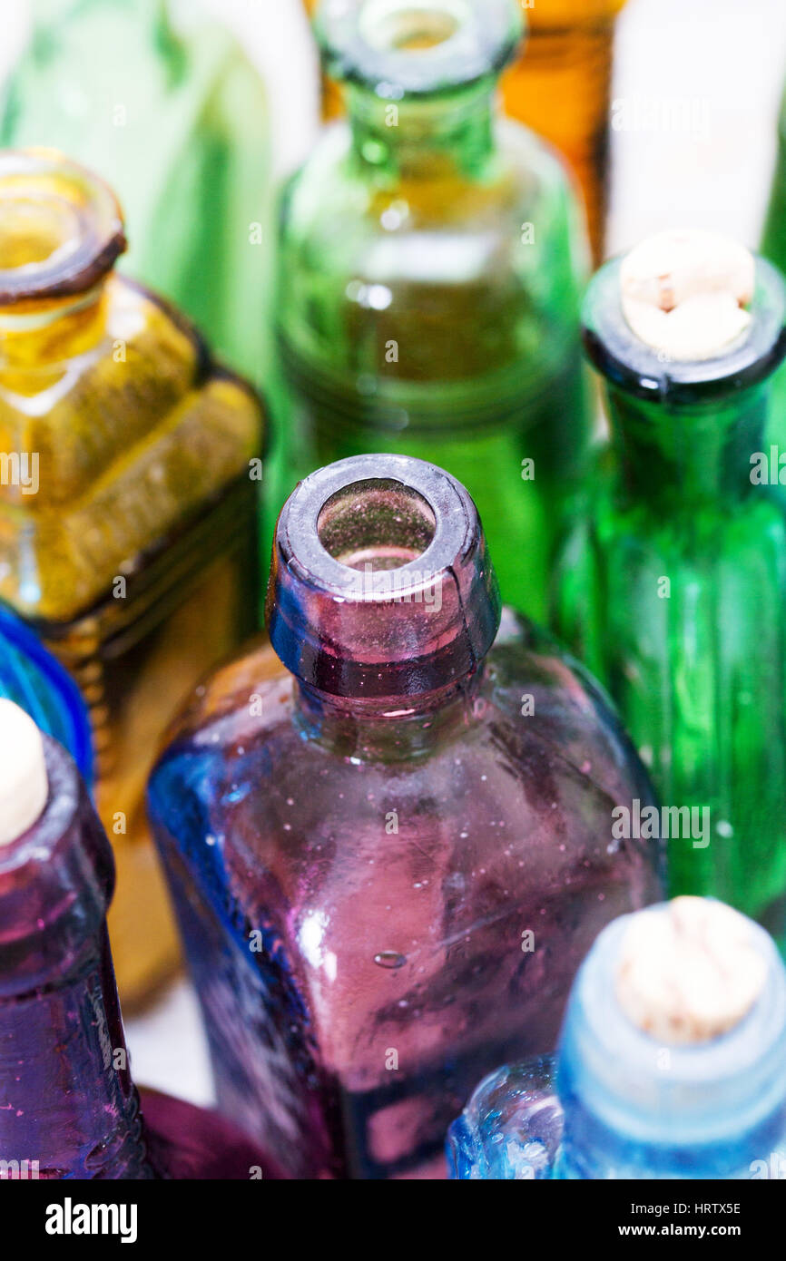 Selection of coloured glass bottles on a rustic background Stock Photo ...