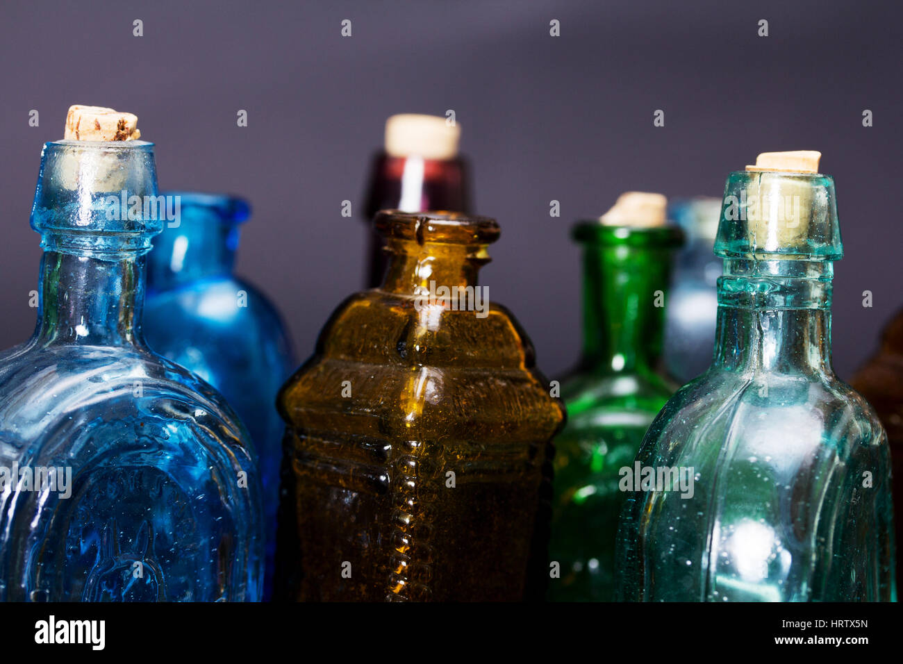 Old colourful vintage bottles against a dark background Stock Photo - Alamy