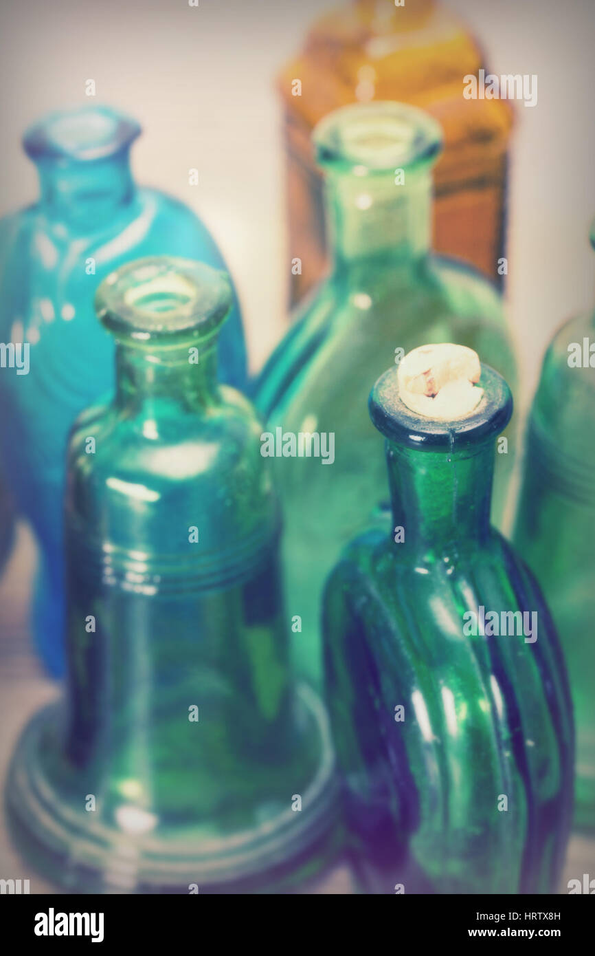 Selection of coloured glass bottles on a rustic background Stock Photo ...