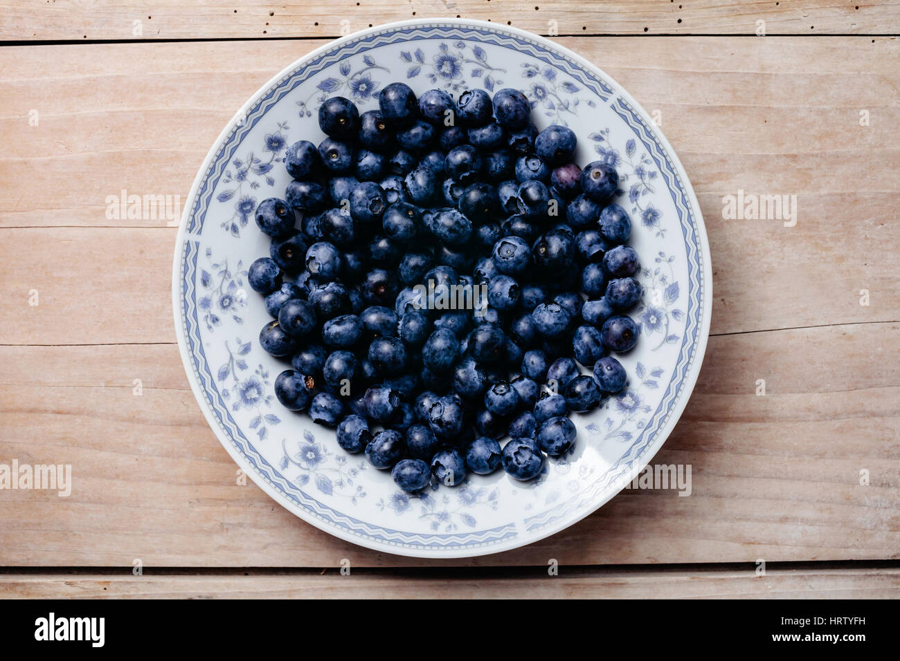 fresh juicy blueberry on plate and wood table top view Stock Photo - Alamy