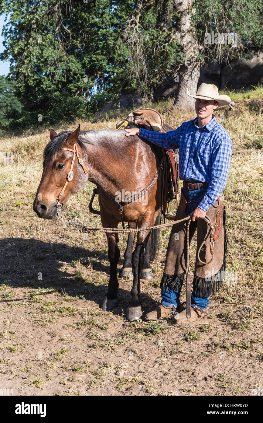 cowboy with horse in field on ranch Stock Photo - Alamy