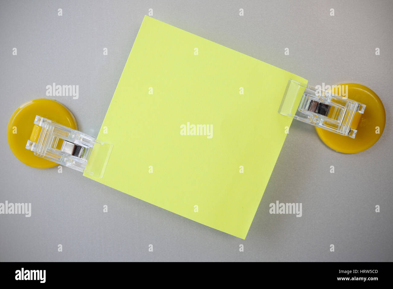 Yellow post it clip by yellow clip magnet on gray refrigerator ...