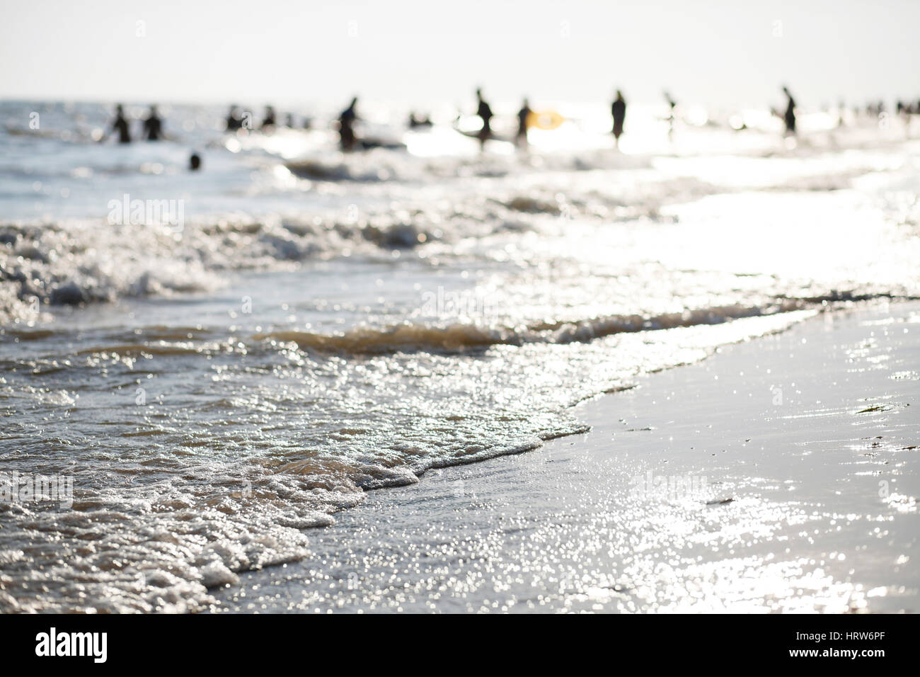 Sea wave on sand beach. people resting in water Stock Photo - Alamy