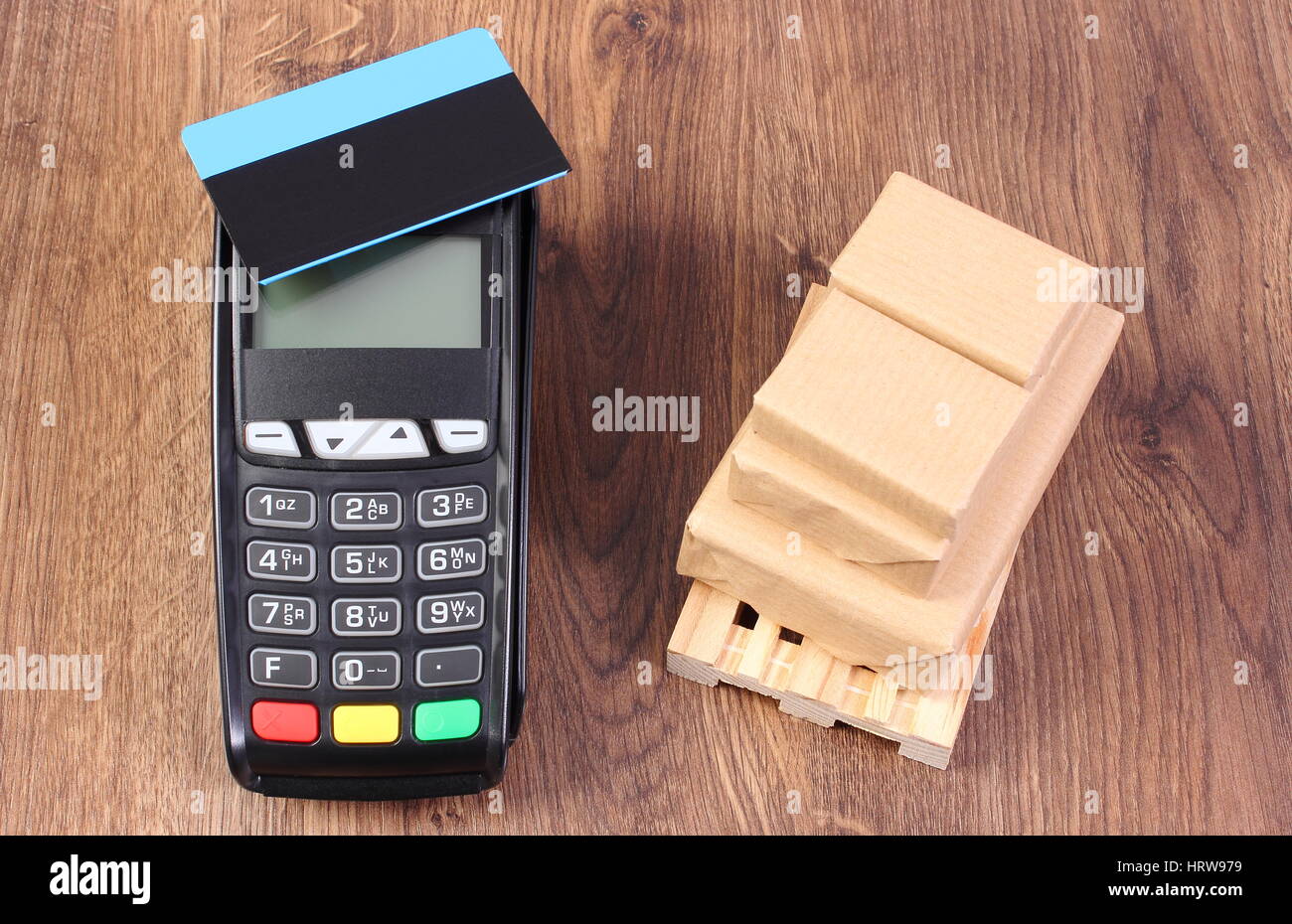 Payment terminal with contactless credit card and small wrapped boxes ...