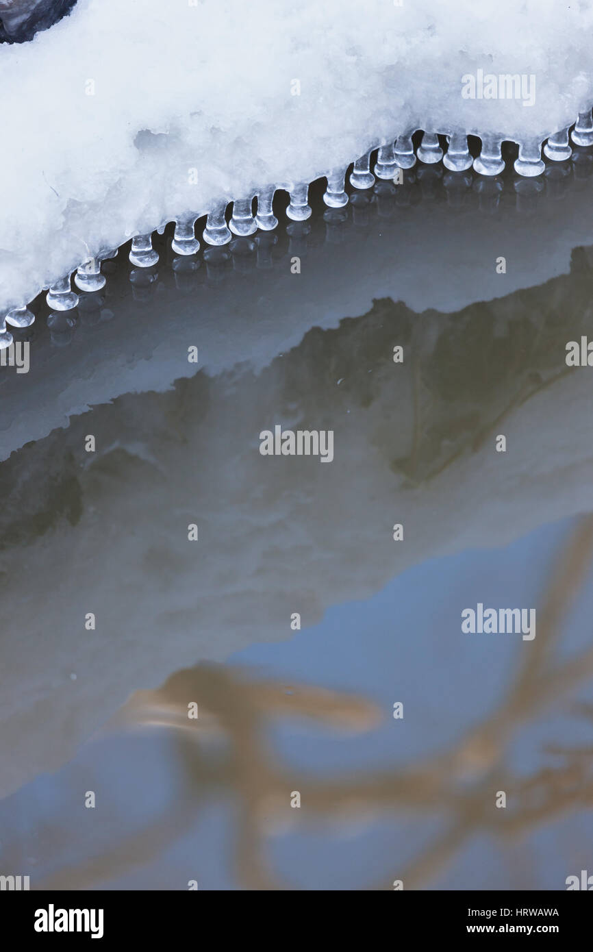 Small round icicles over water perfect reflection Stock Photo - Alamy
