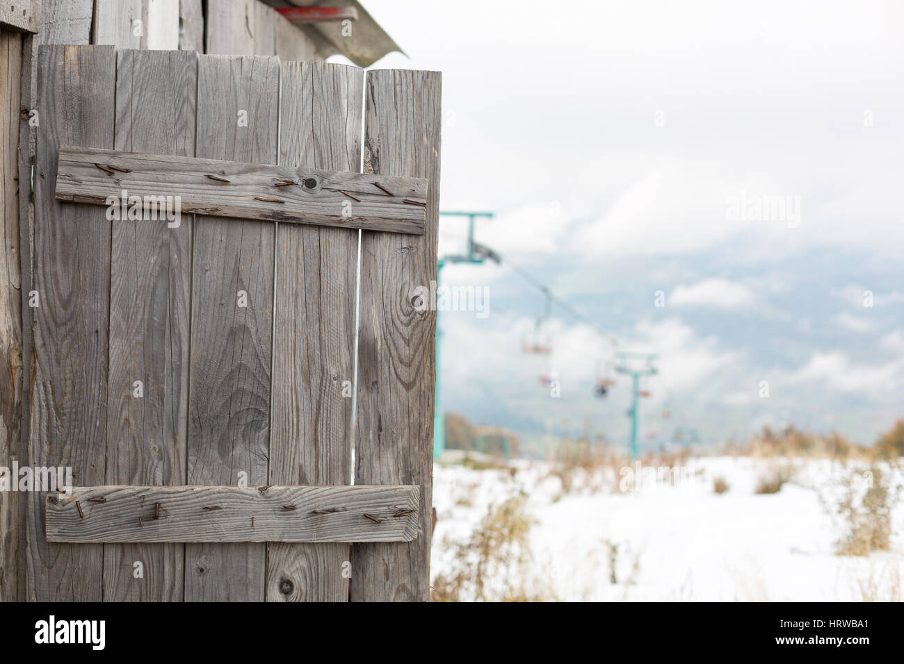 Open wooden door of the old barn on the background of the chair lift at ...