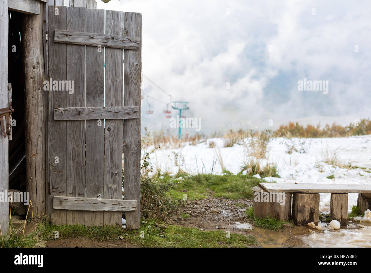 Open wooden door of the old barn on the background of the chair lift at ...