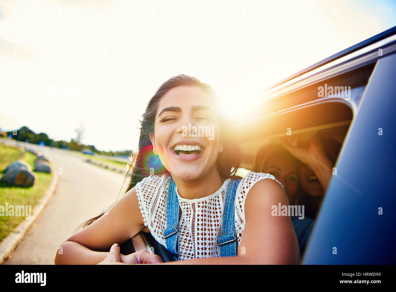 Pretty Woman In Speeding Car Smiles At Camera While Friends Laugh In