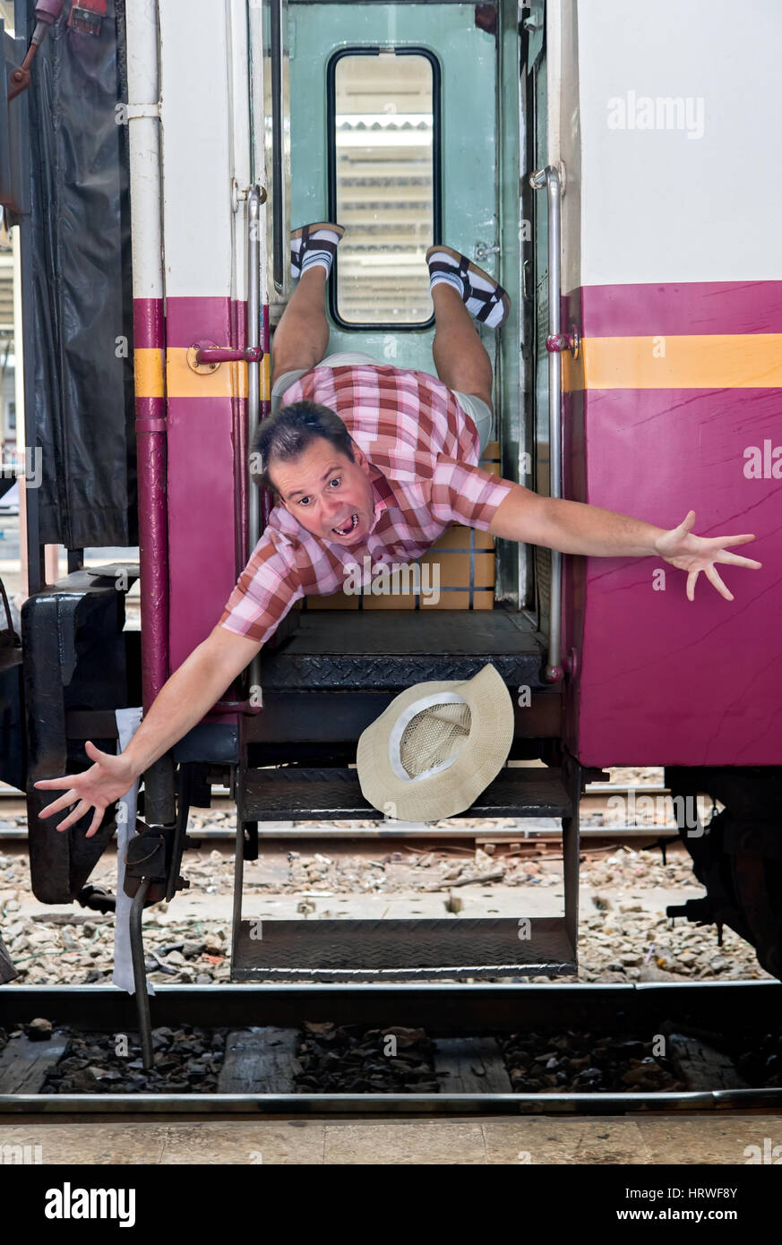 Tourist falls out of the open doors of the train on the platform ...