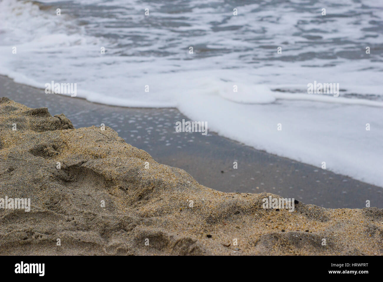 Sand cliff with beach waves in background Stock Photo - Alamy
