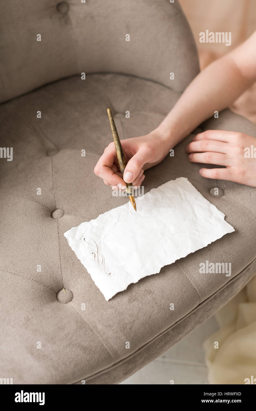 the girl writes the letter with a feather for a calligraphy on vintage ...