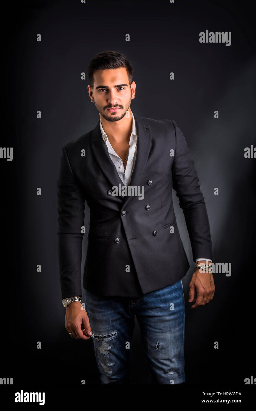 Young businessman confidently posing in front of camera, wearing ...