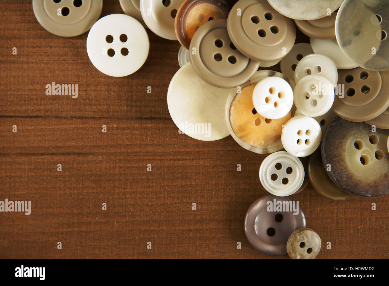Stack of old fashioned brown beige and white buttons on a wooden ...