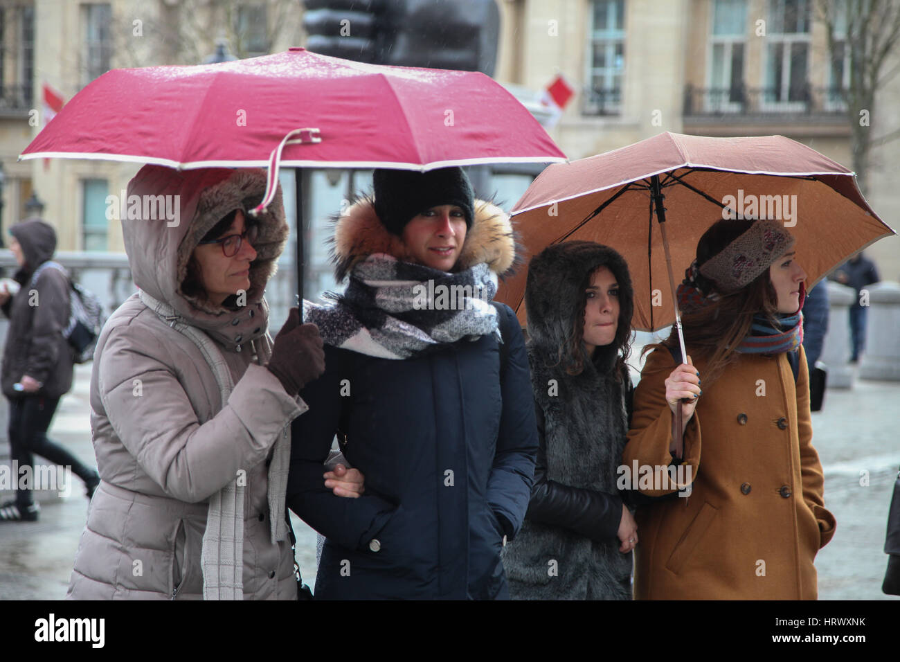 Trafalgar Square . London. UK 4 Mar 2017 - Tourists shelter under ...