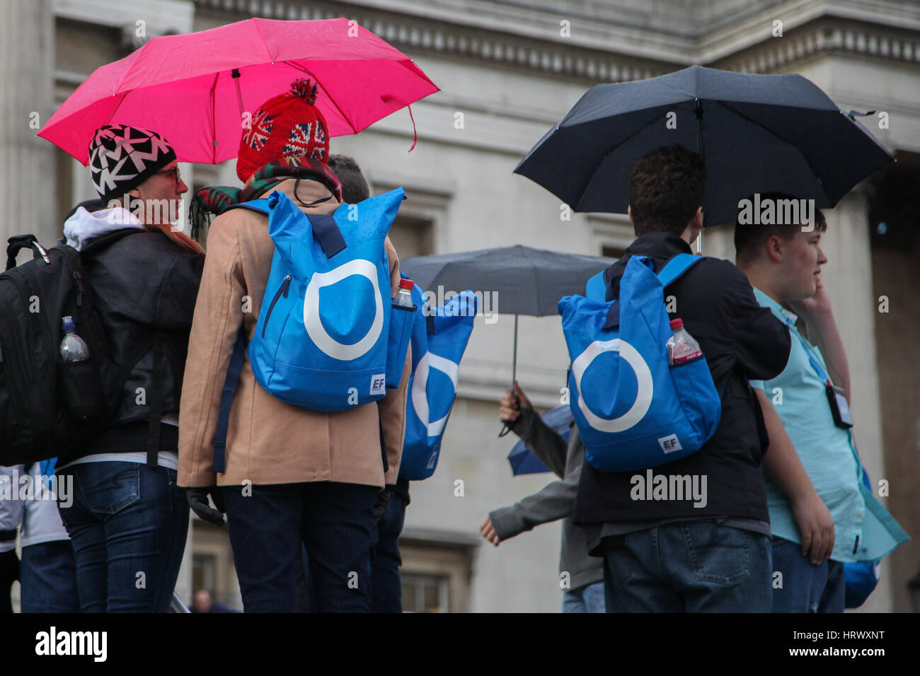 Trafalgar Square . London. UK 4 Mar 2017 - Tourists shelter under ...