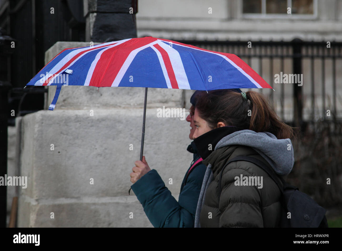 Trafalgar Square . London. UK 4 Mar 2017 - Tourists shelter under ...