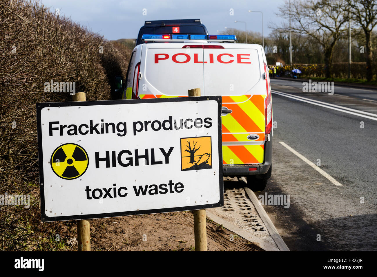 Police van parked on the grass verge behind an anti-fracking sign near ...
