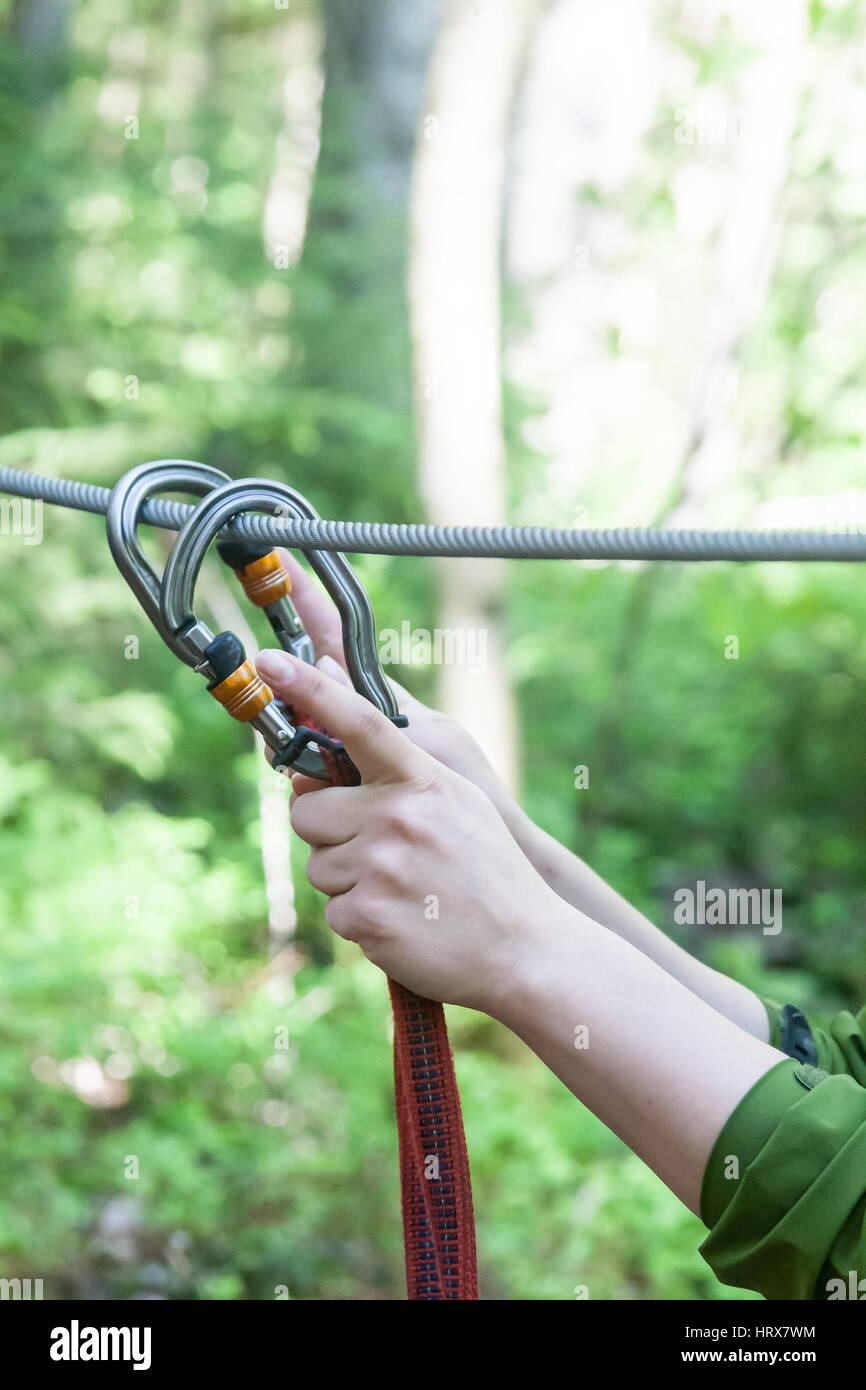 hands of the girl clinging carbines to a cable in rope park Stock Photo ...