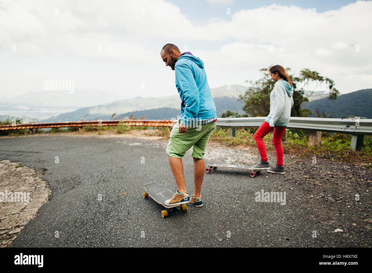 longboarding couple in tropics with mountain view Stock Photo - Alamy