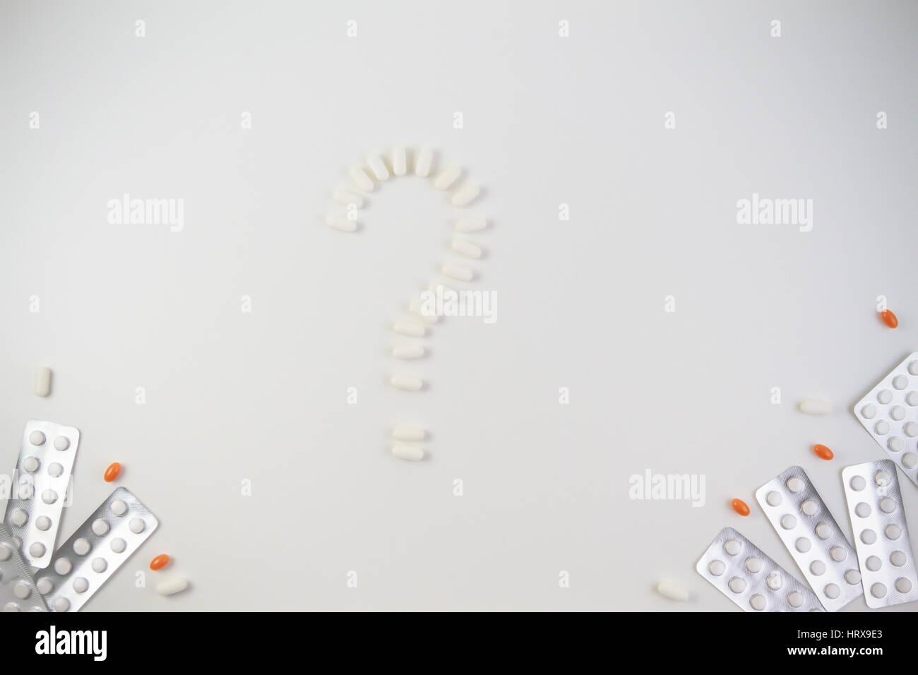 Pills in the shape of a question mark and tablets on white background ...