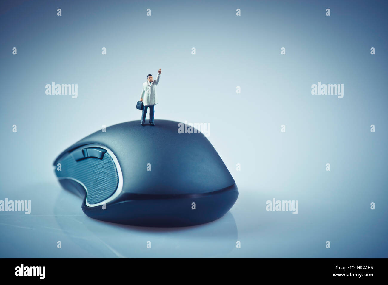 Miniature businessman waving on top of computer mouse. Business concept ...