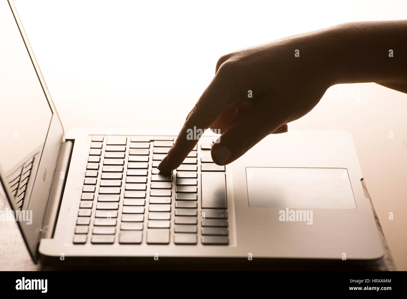 A woman's hand presses a key of a laptop keyboard Stock Photo - Alamy