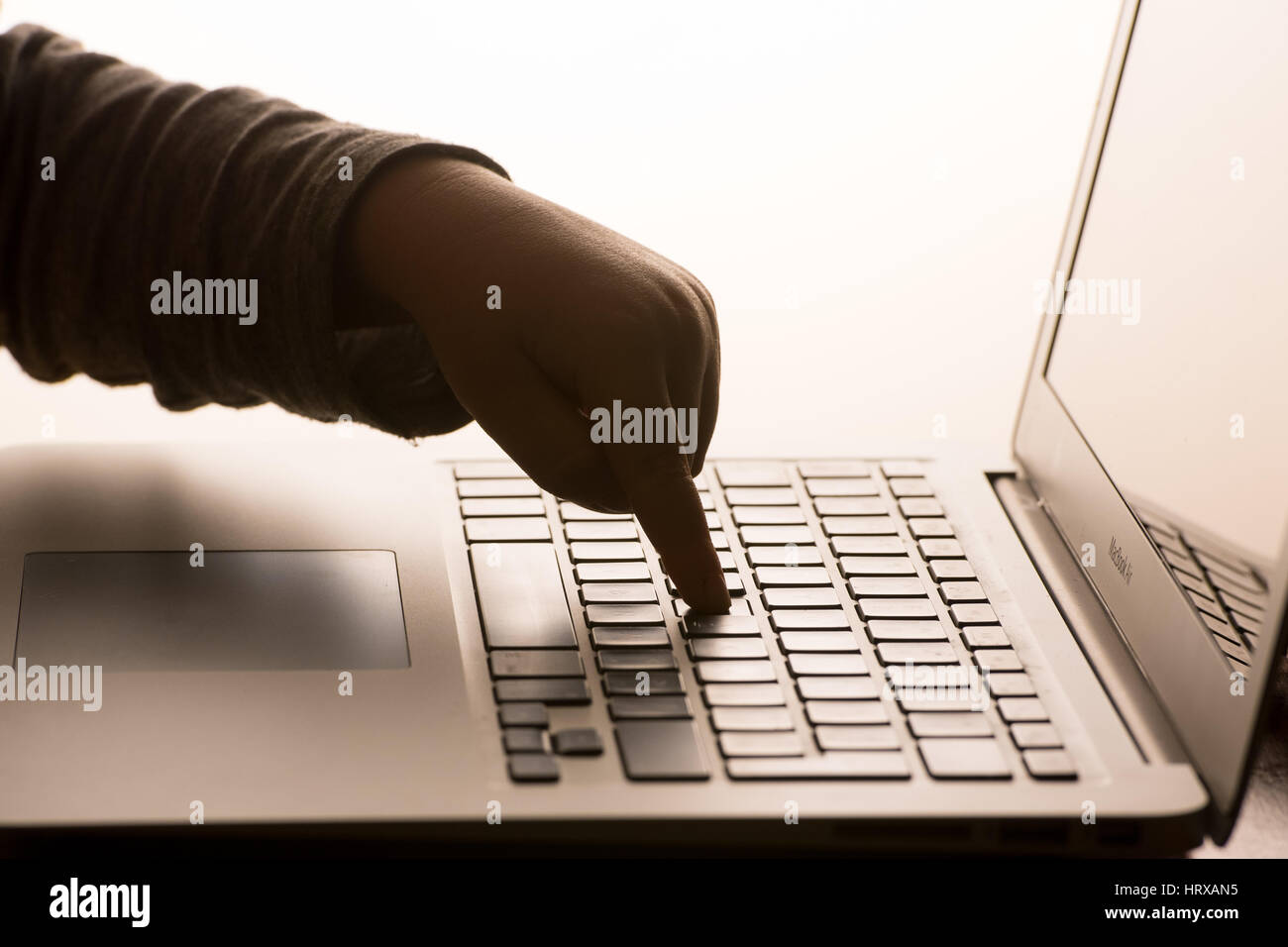 A child's hand presses a key of a laptop keyboard Stock Photo - Alamy