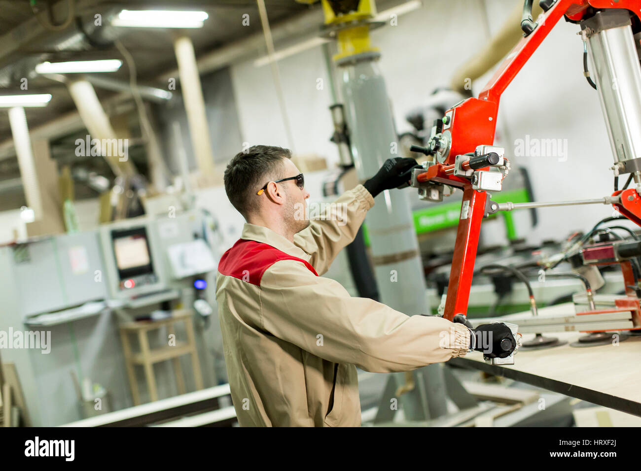 Young worker works in a factory for the production of furniture Stock ...