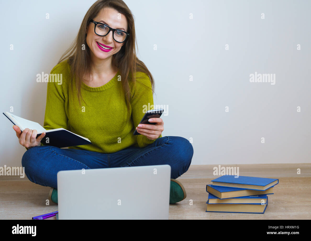 Beautiful girl using laptop sitting on the floor at home - modern ...