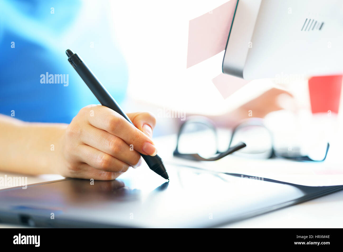 Female artist drawing something on graphic tablet at the home office ...