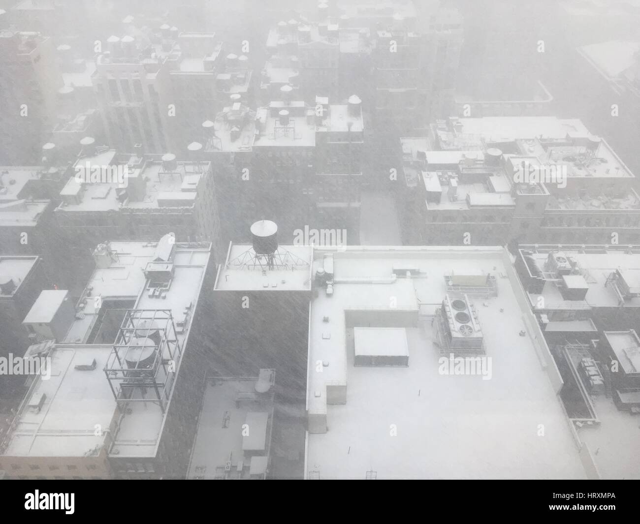 Looking out of a skyscraper window down on the snow-covered roofs below ...