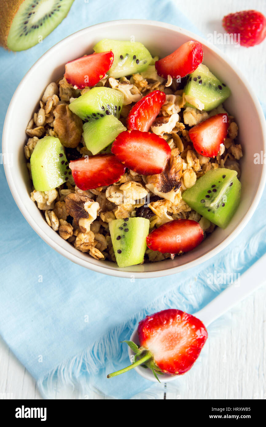 Homemade granola with fruits (strawberry and kiwi) in white bowl for ...