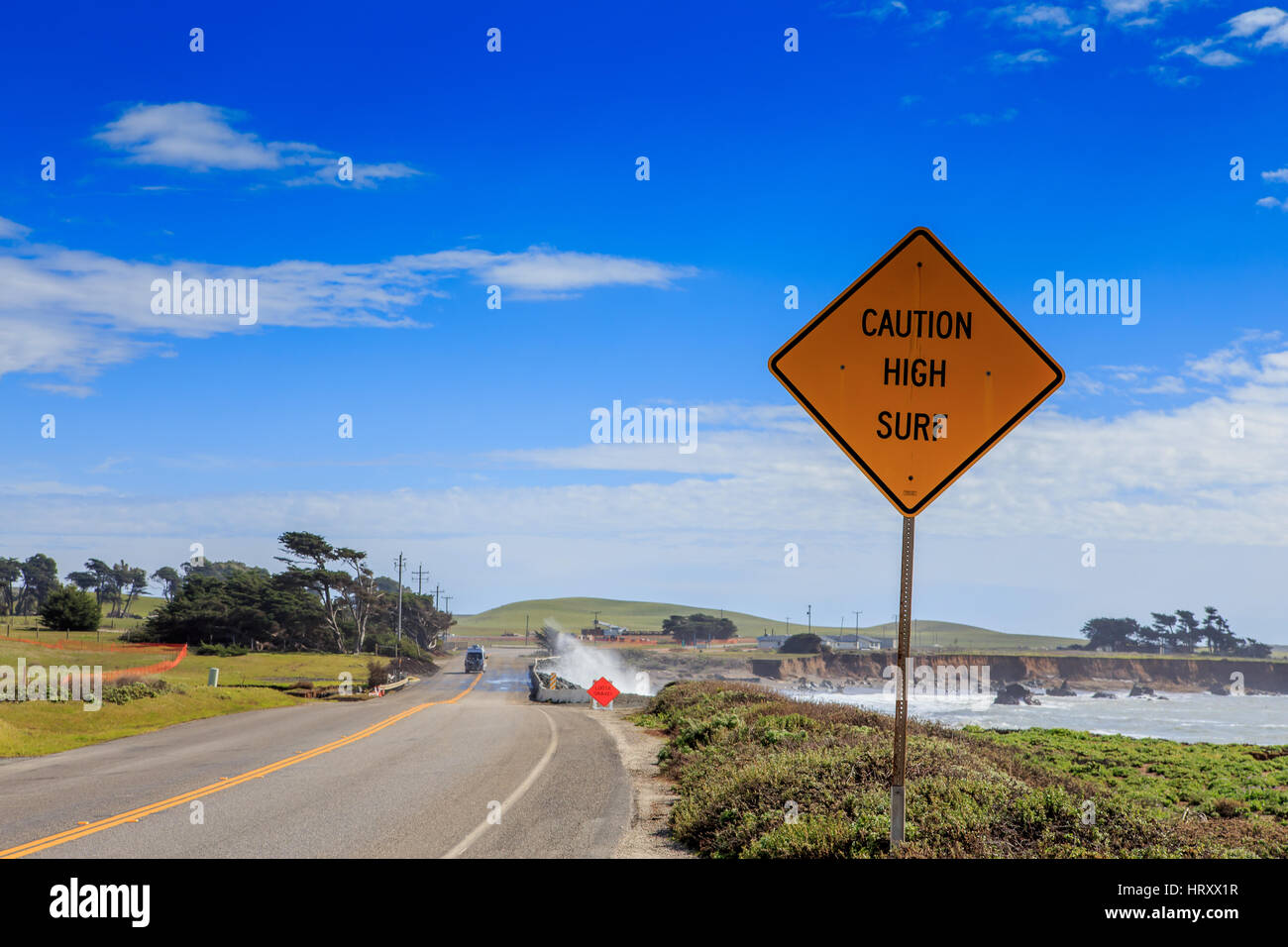 Caution high surf warning sign on the roadside of famous highway 1 on ...