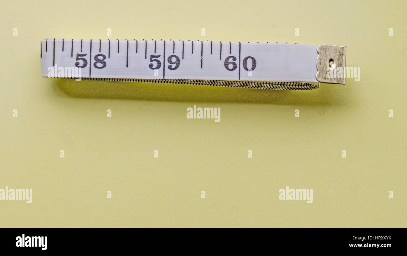 A coiled up tape measure on a pale background Stock Photo - Alamy