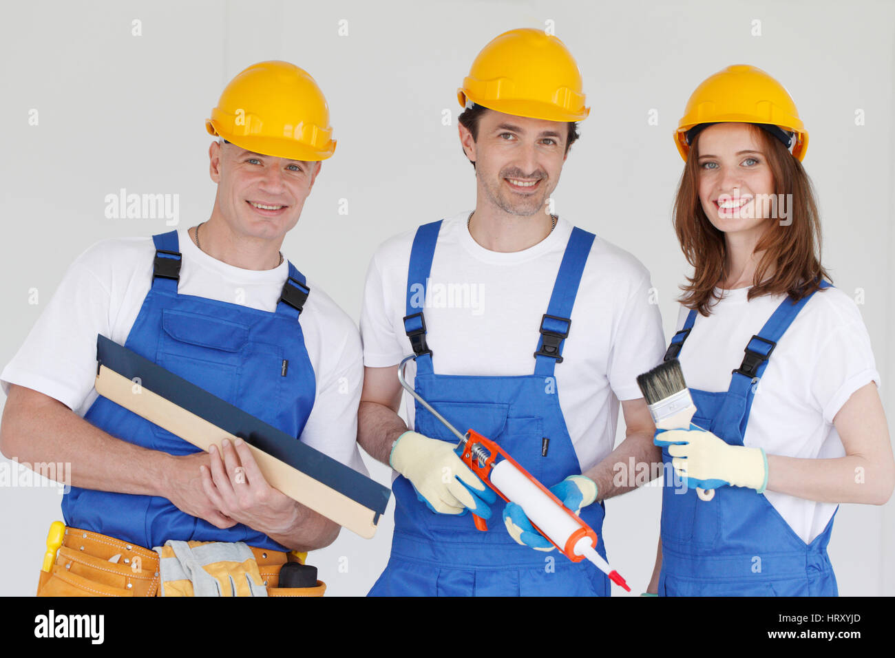 Team of cheerful workers in uniform and hardhats with tools Stock Photo ...