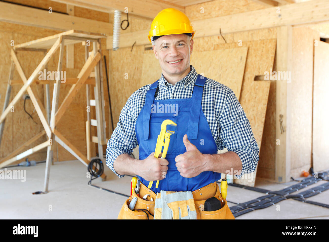 Construction worker with wrench at construction site Stock Photo - Alamy